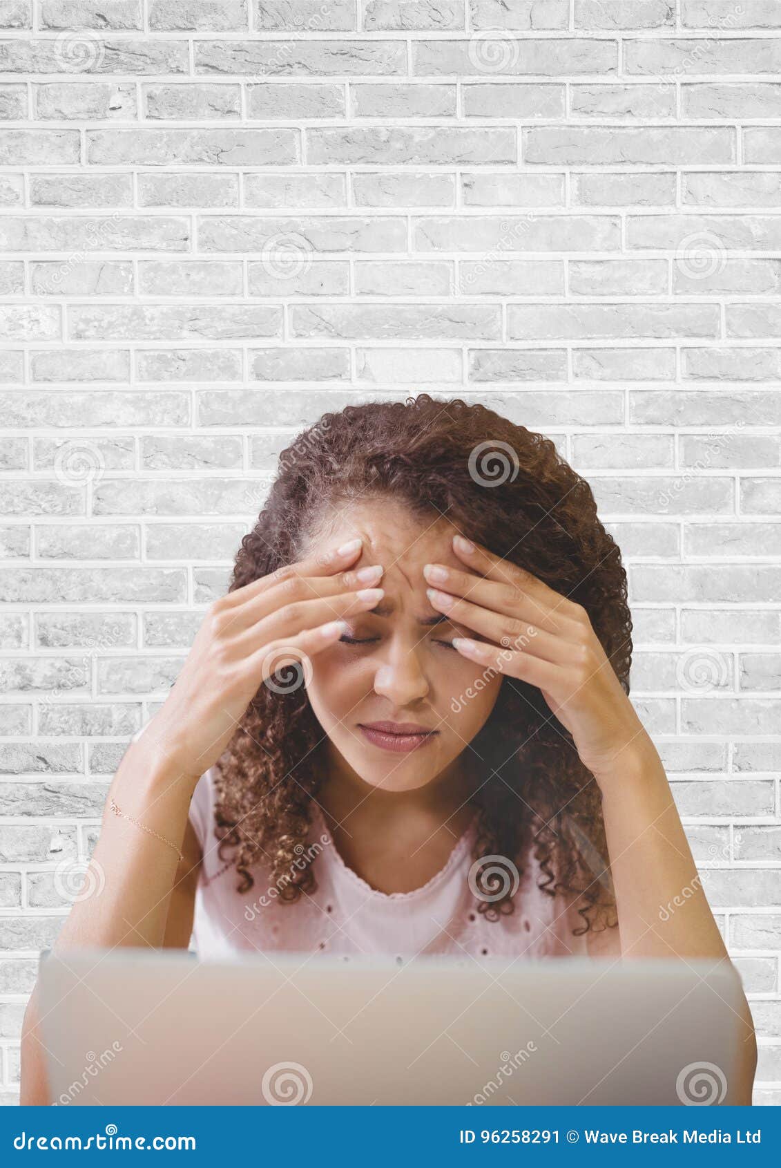 Frustrated Business Woman at a Desk Using a Computer Against White Wall ...