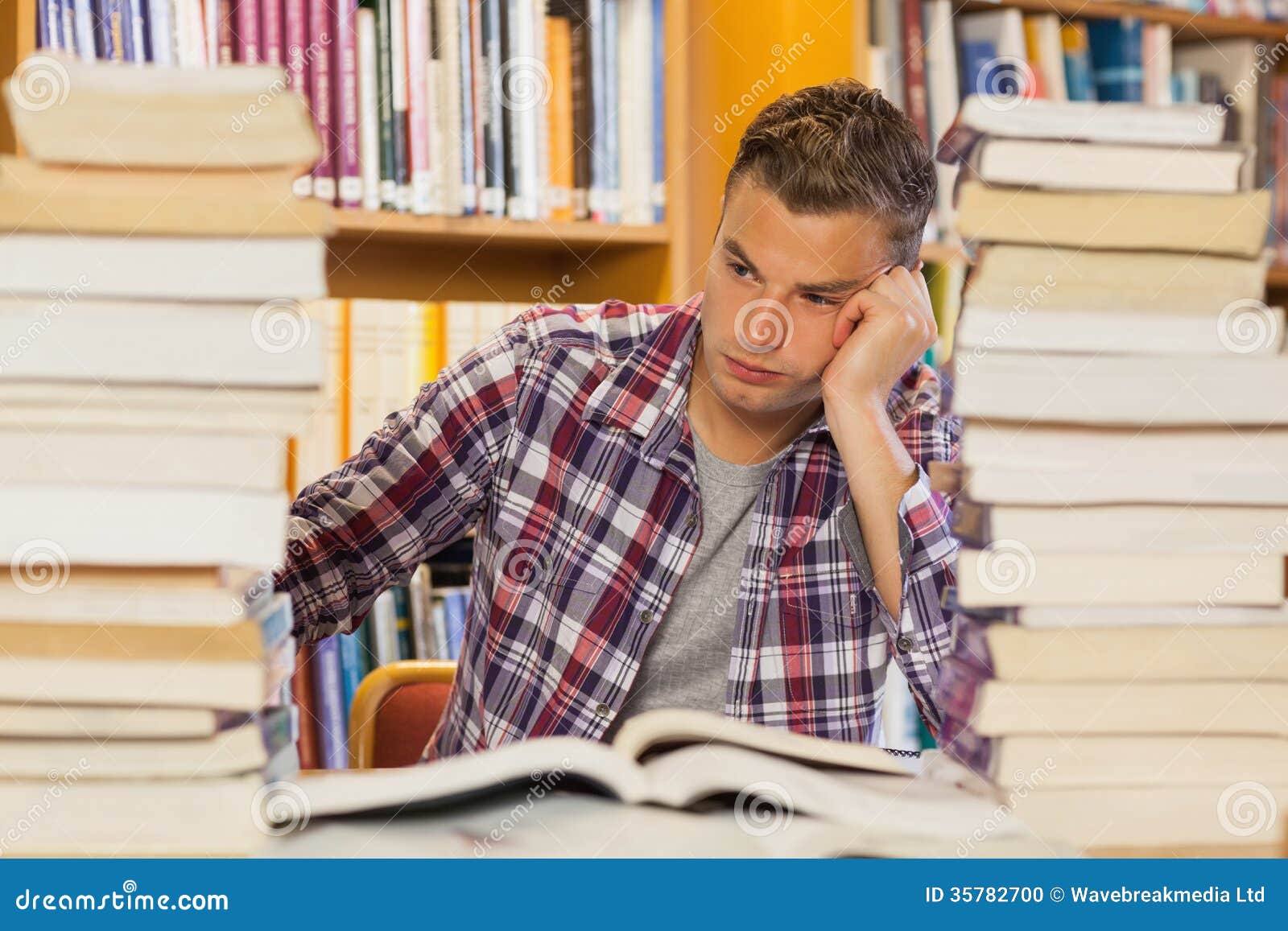 Frustrated Handsome Student Studying between Piles of Books Stock Photo ...