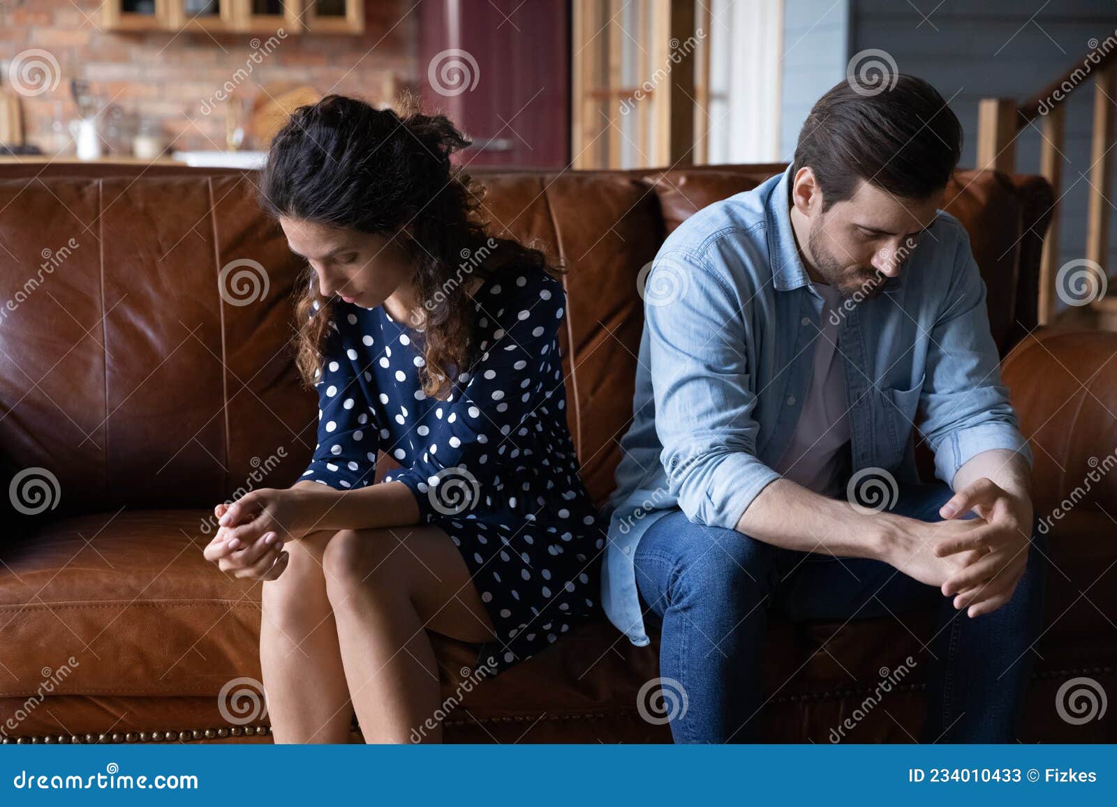 Frustrated Married Couple Sit On Couch After Quarrel Avoid Talking