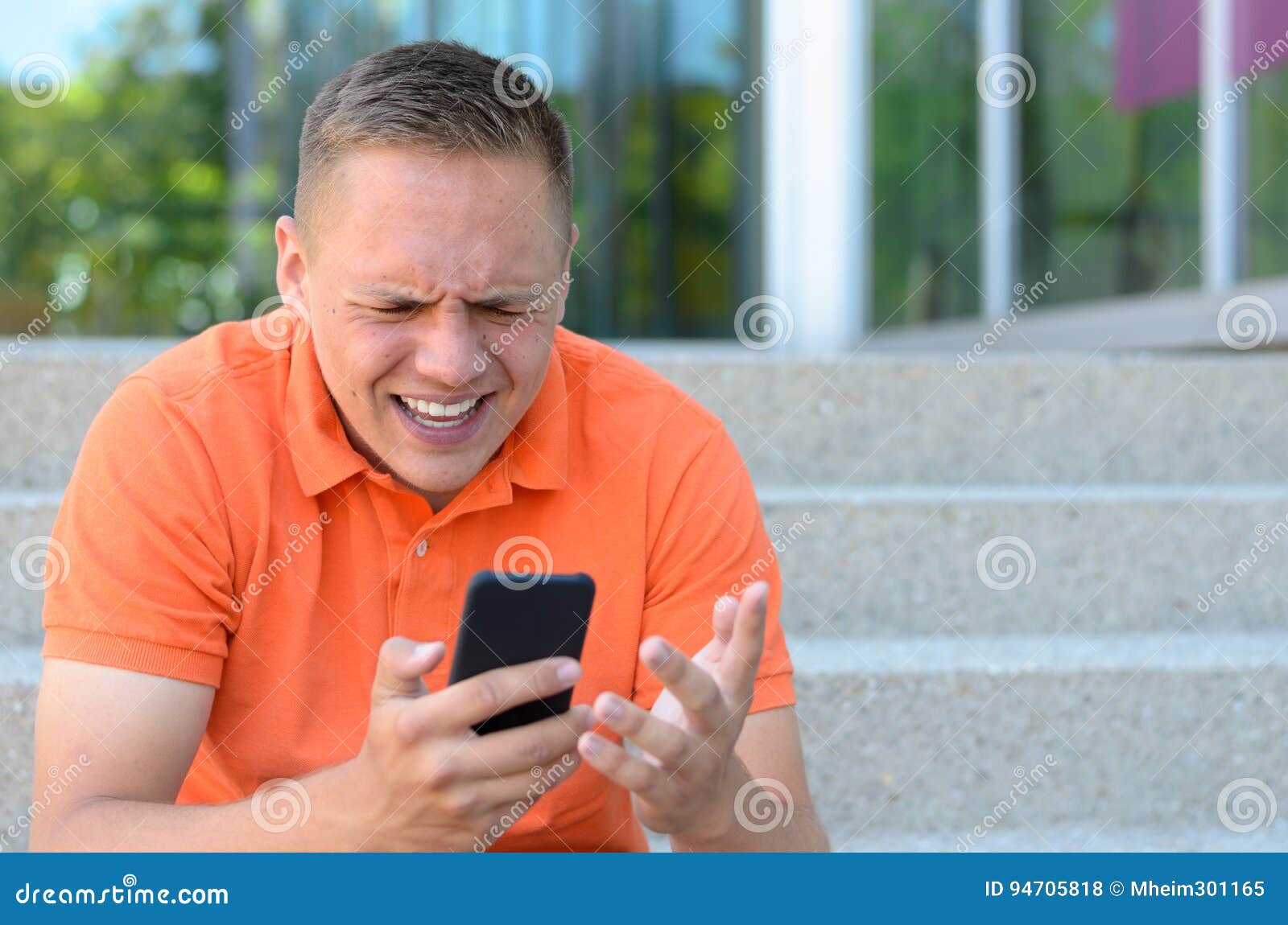 Frustrated Young Man Gesturing at His Mobile Phone Stock Photo - Image ...
