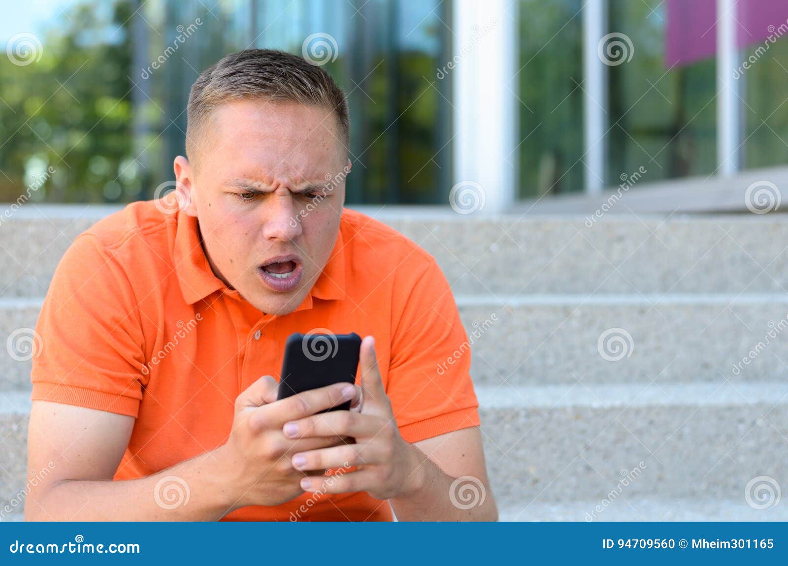 Frustrated Young Man Gesturing at His Mobile Phone Stock Photo - Image ...