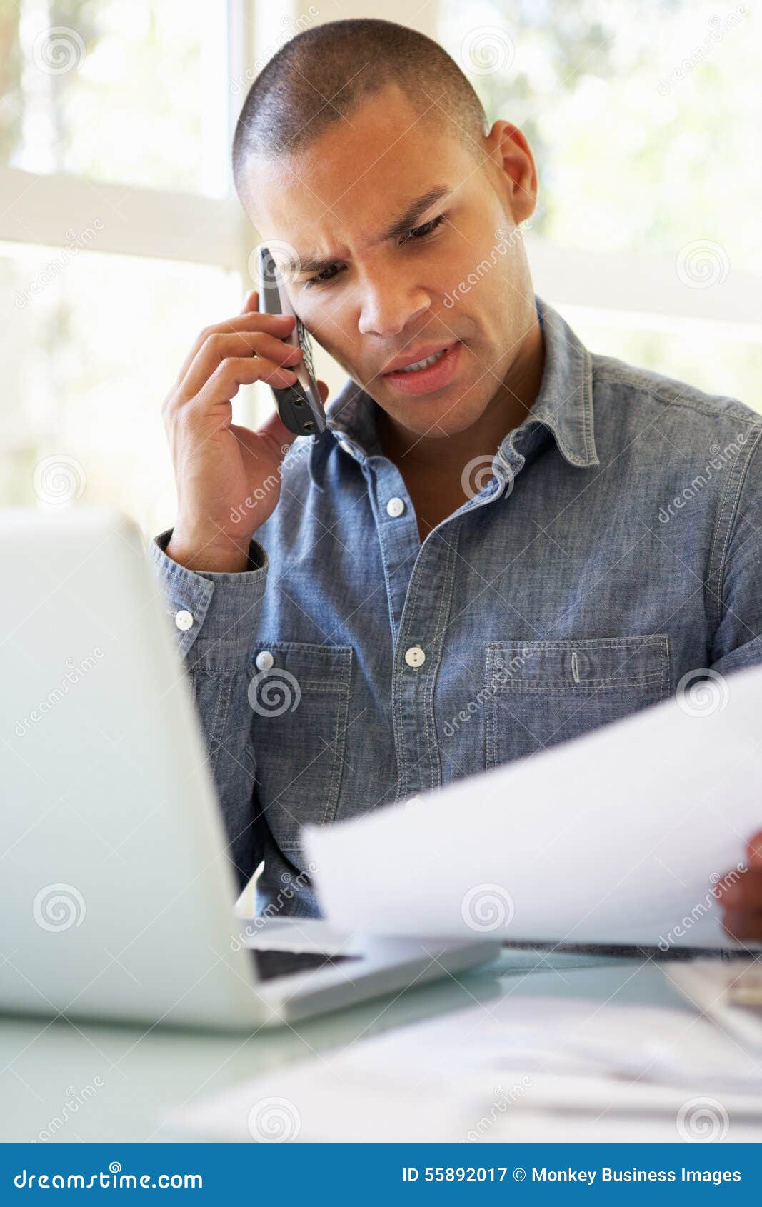 Frustrated Young Man on Phone Using Laptop at Home Stock Image - Image ...