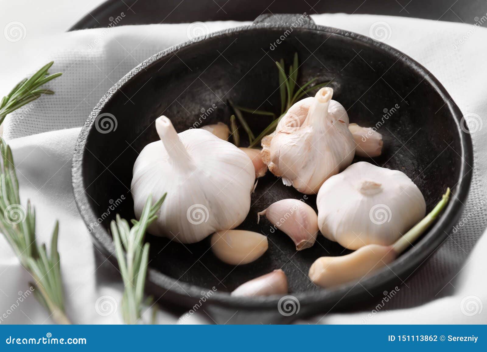 Frying Pan with Fresh Garlic and Rosemary on Table Stock Photo - Image ...