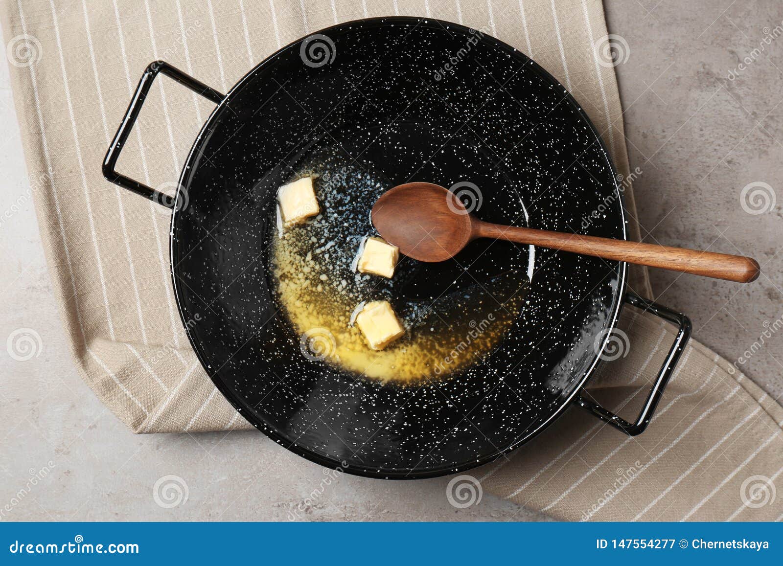Frying Pan with Melting Butter and Spoon on Grey Table Stock Image ...