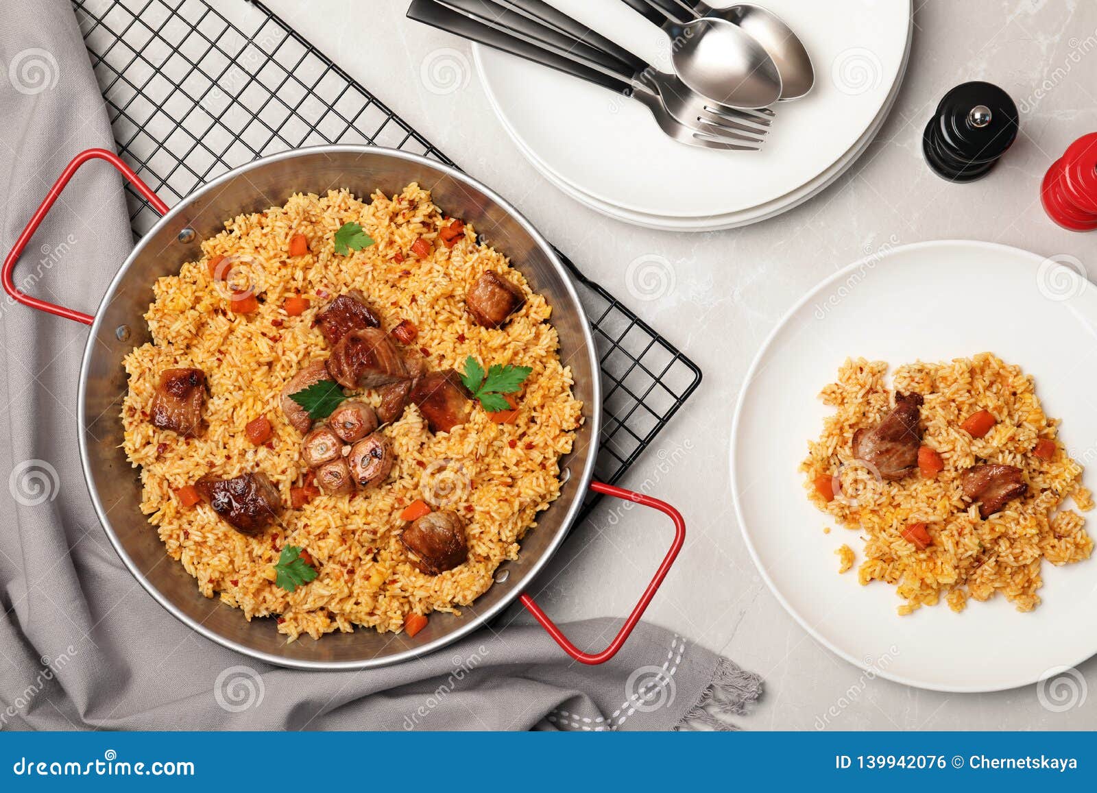 Frying Pan and Plate with Delicious Rice Pilaf on Light Table Stock ...