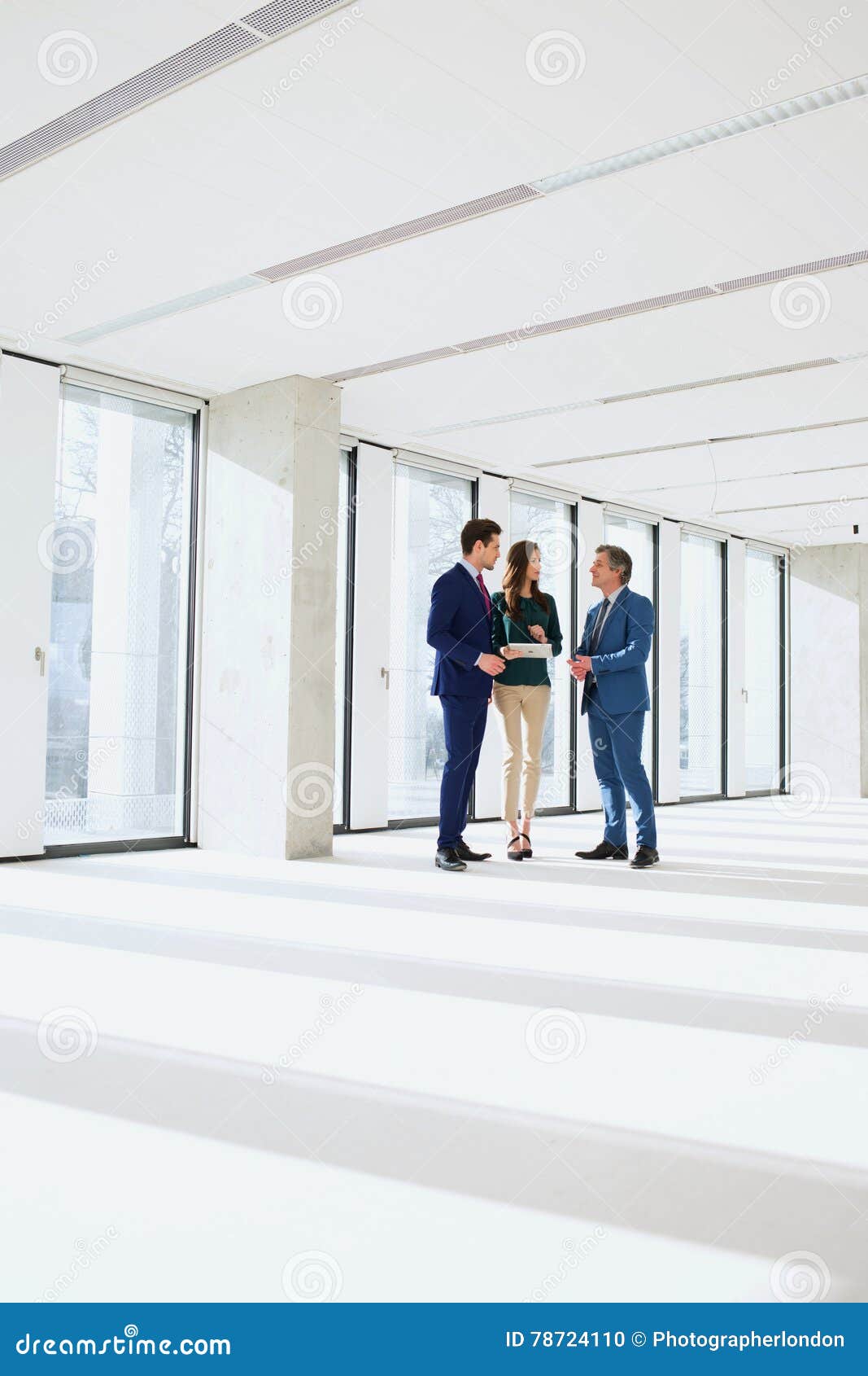Full Length of Business People Having Discussion in Empty Office Stock ...