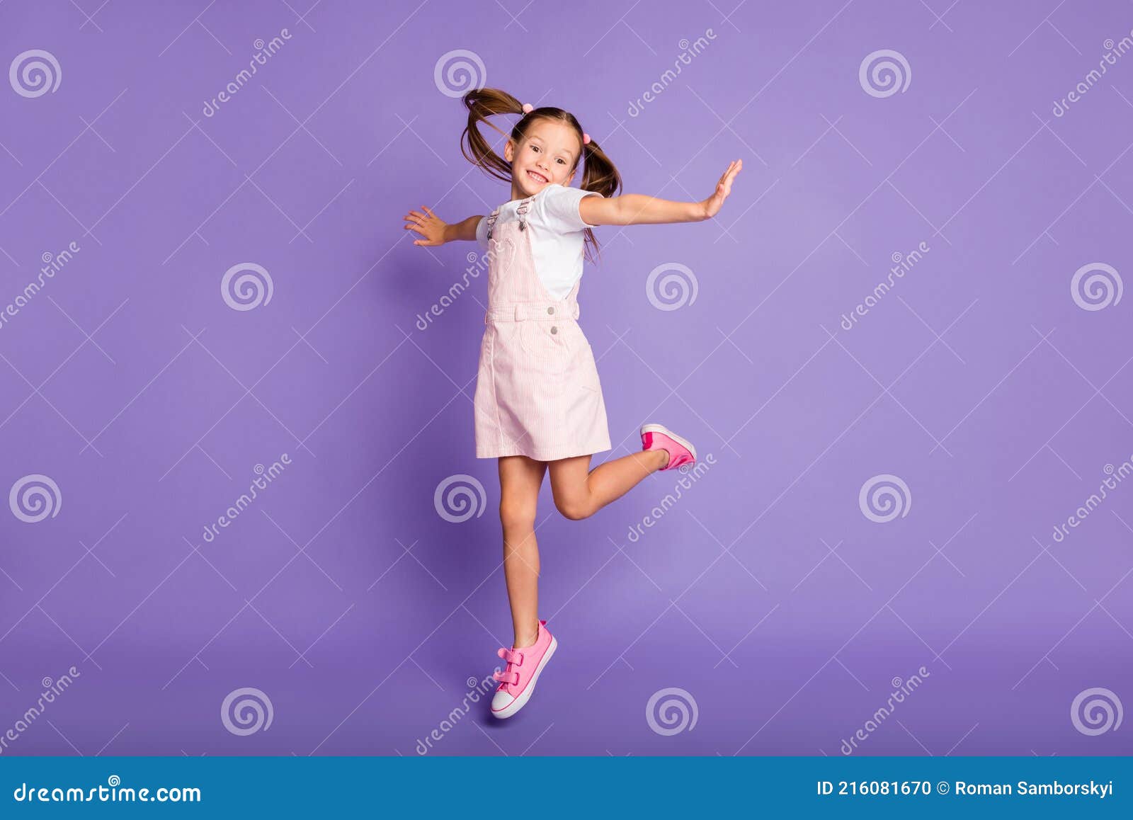 Full Length Of Carefree Happy Small Girl Wear Pink Dress Raise Hands