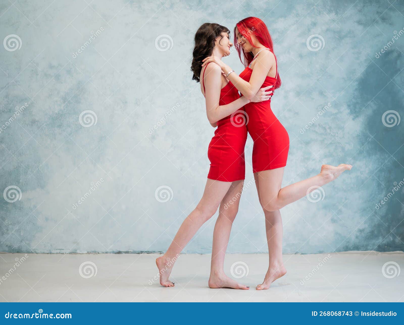 Full Length Portrait Of Two Tenderly Embracing Women Dressed In