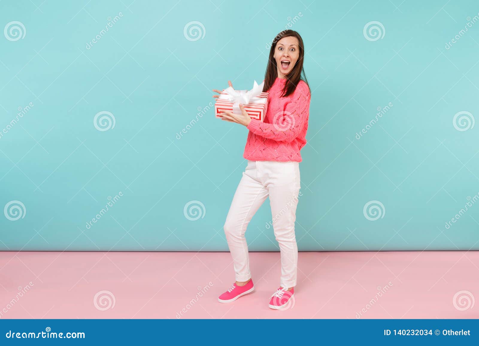 Full Length Portrait Of Woman In Knitted Rose Sweater White Pants