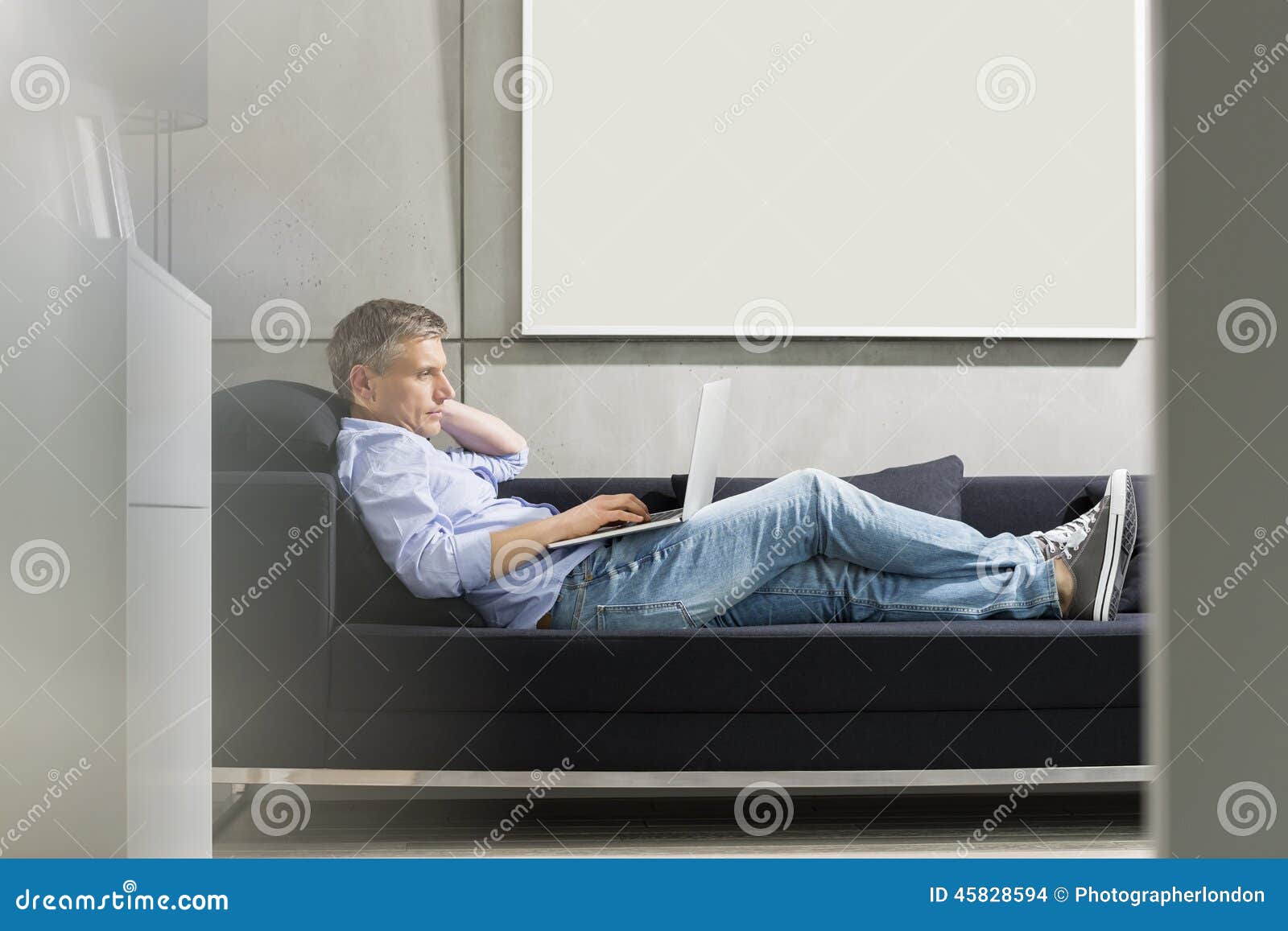 Full-length Side View of Middle-aged Man Using Laptop while Lying on ...