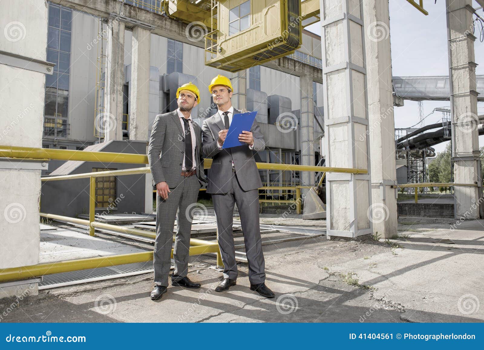 Full Length of Young Male Engineer with Clipboard Looking Away at ...
