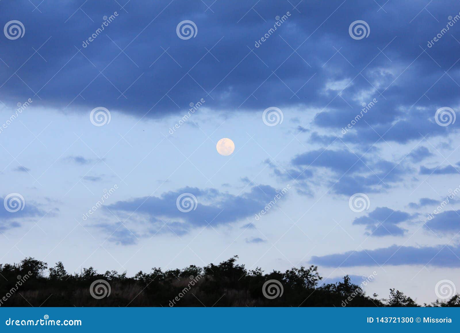 Full moon in the sunset stock photo. Image of clouds - 143721300