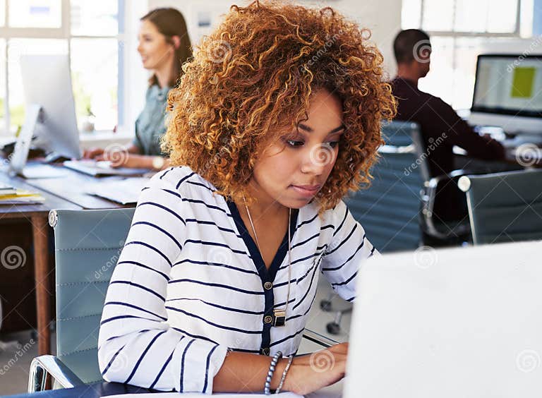 Fully Engaged in Her Work Tasks. a Young Woman Using a Computer at Her ...