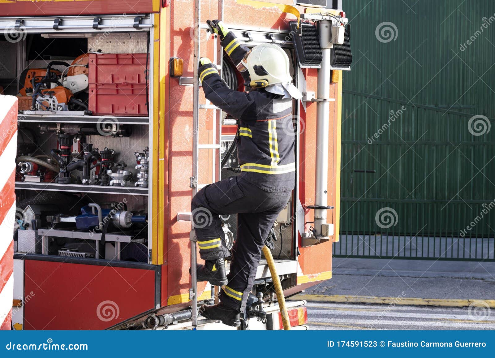 Fully Equipped Fireman Climbing the Ladder of a Fire Truck Stock Image ...