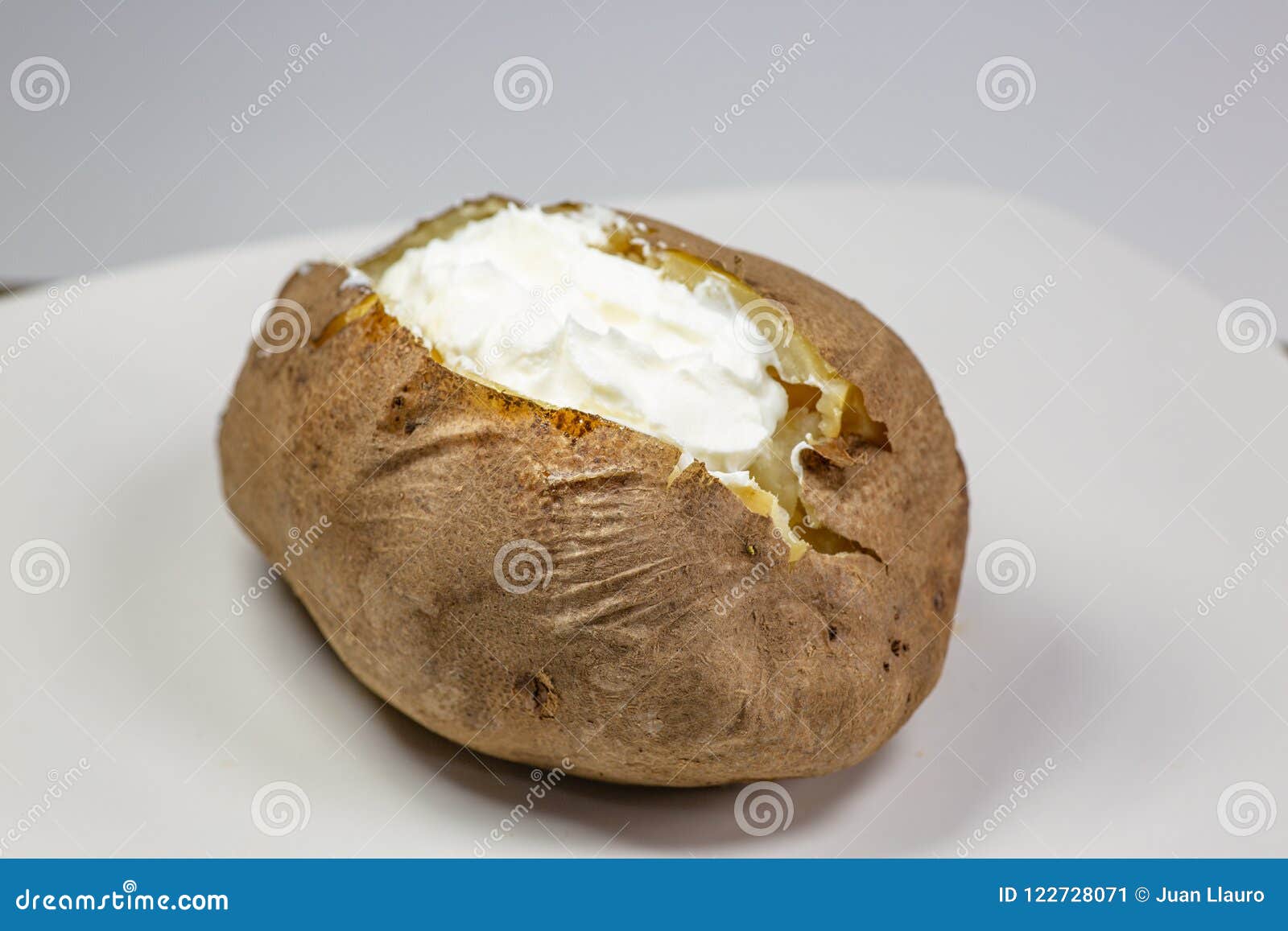 Fully Loaded Baked Potato on a White Plate on the Kitchen Table Stock ...