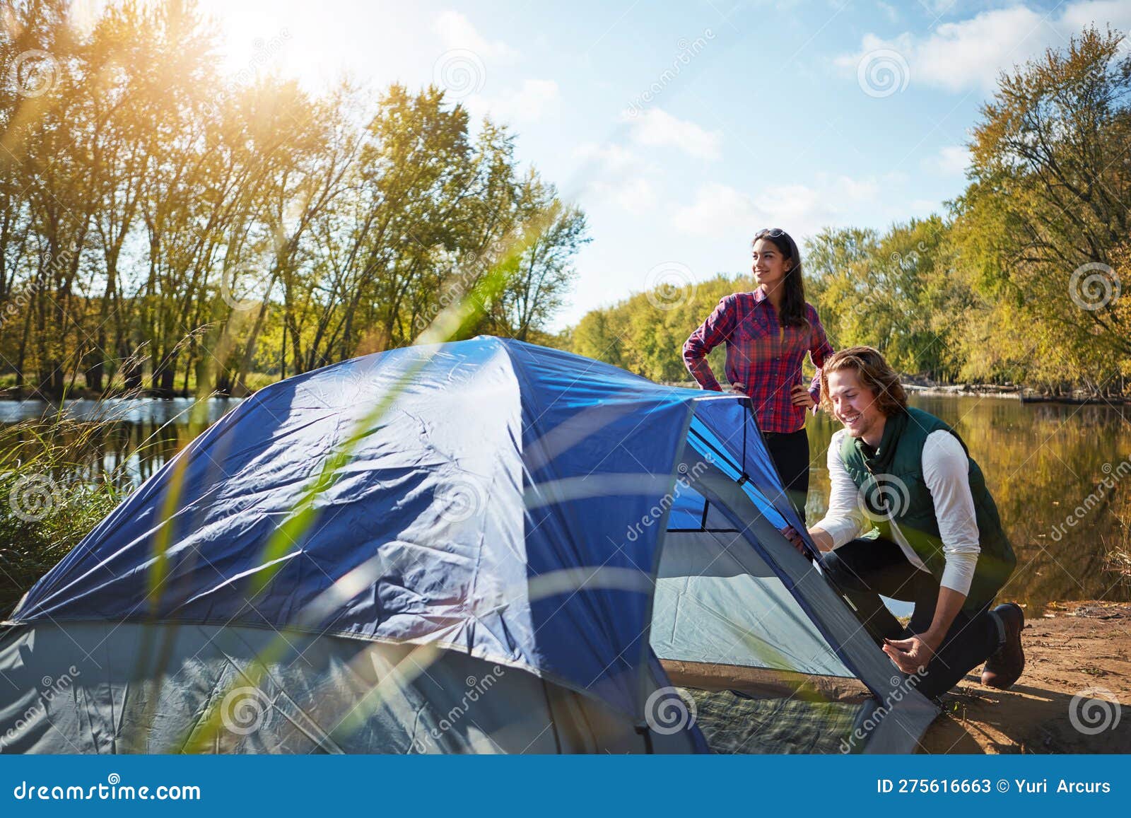 The Fun Begins Here. an Adventurous Setting Up Their Tent by the Lake ...