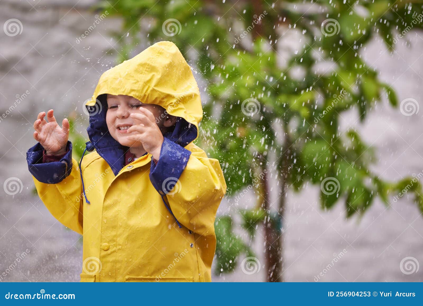 Fun in the Rain. an Adorable Little Boy Playing Outside in the Rain ...