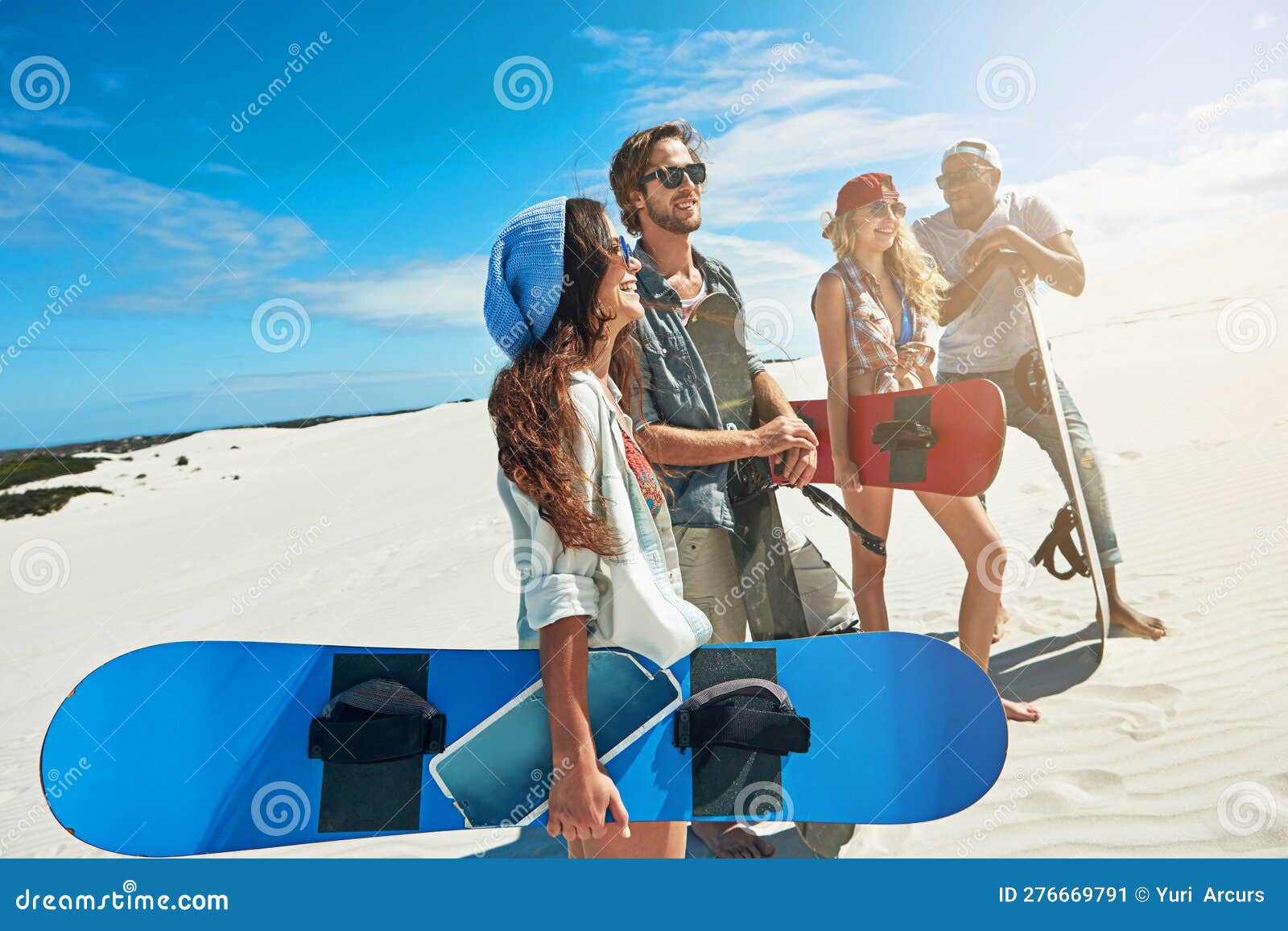 Fun Under the Desert Sun. a Group of Young Friends Sandboarding in the ...