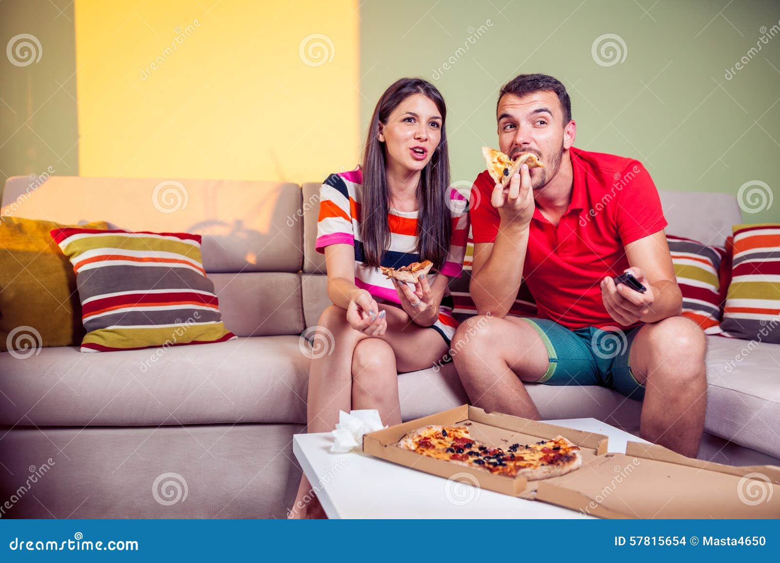 Funky Young Couple Eating Pizza on a Couch Stock Photo - Image of lunch ...