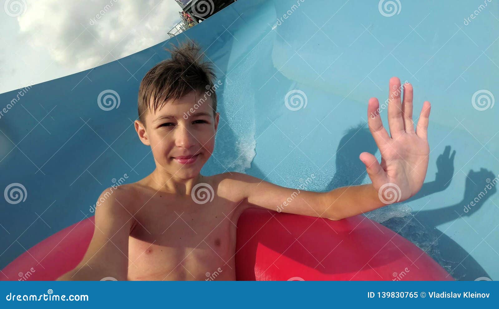 Funny Boy Goes Down on the Water Slide in the Water Park Looks into the ... Funny Boy Goes Down on the Water Slide in the Water Park Looks into the ...