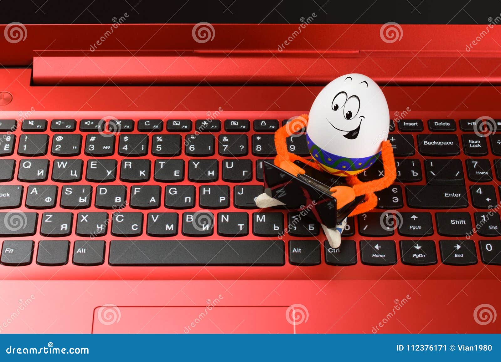 Funny Easter Egg Working on a Red Notebook Computer Stock Image - Image ...