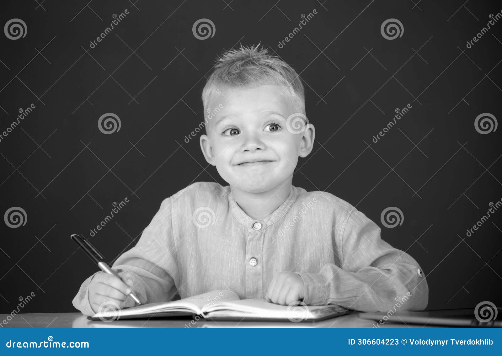 Funny Kid Writing in Notebook in Class. Child at School. Kid is ...