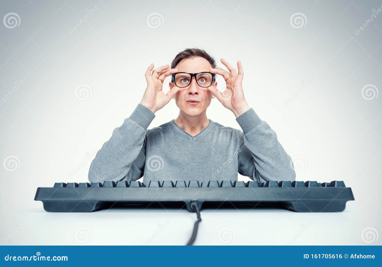 Funny Man Holds Glasses in His Hands while Sitting at a Keyboard in ...