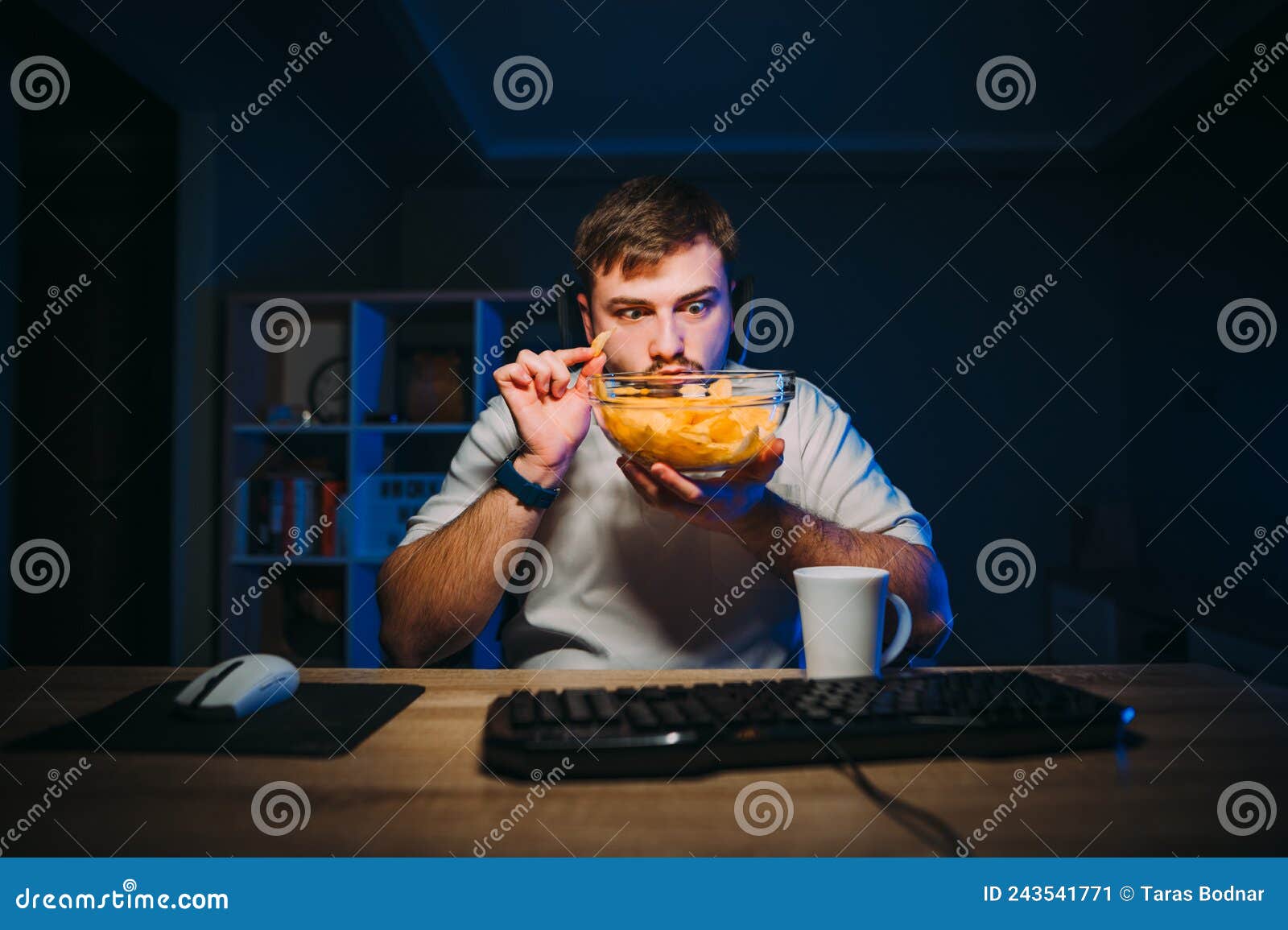 Funny Man Sitting at the Computer at Night and Eating Chips from a ...