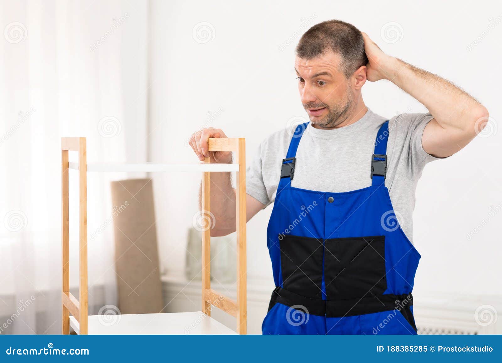 Puzzled Repairman Scratching Head Assembling Cabinet Standing Indoors ...