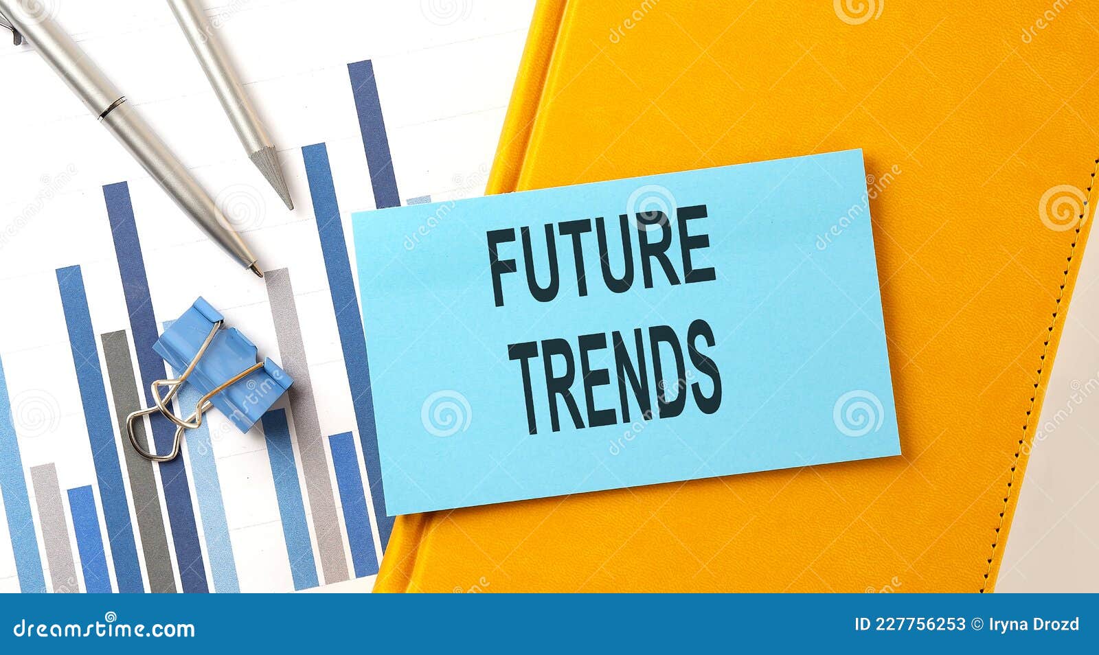 FUTURE TRENDS Text on Sticker on the Yellow Notebook with Chart and Pen ...