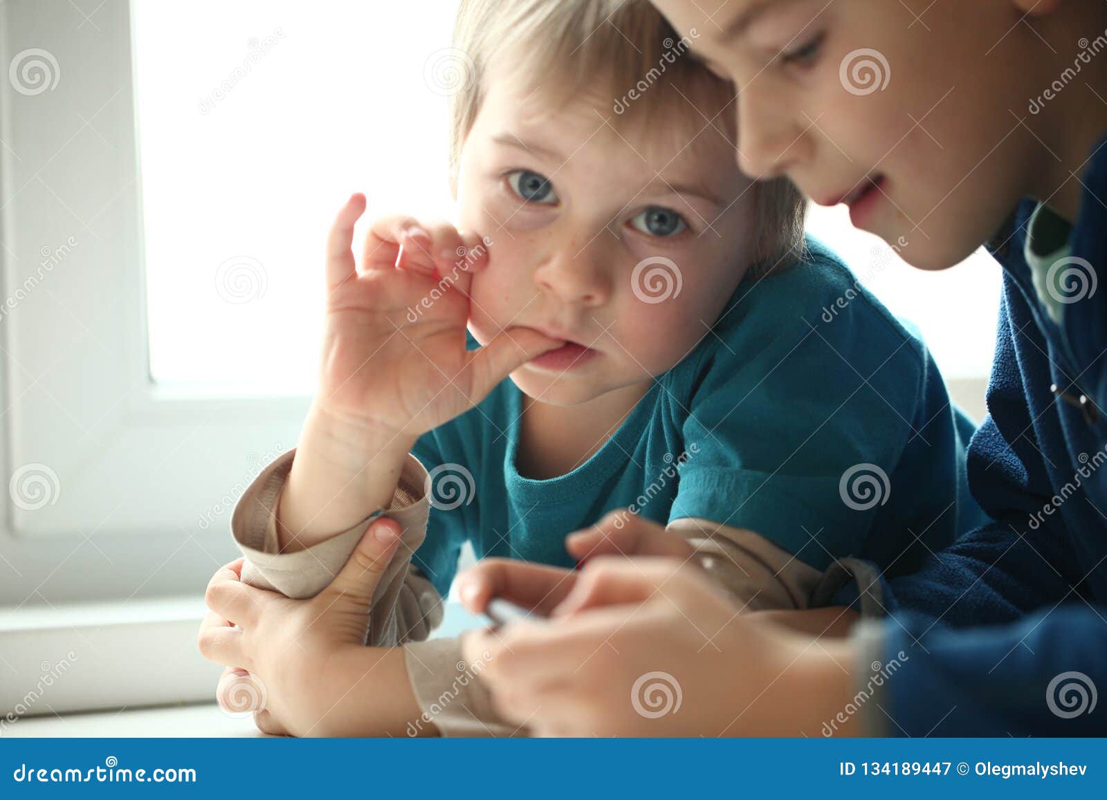 Game Addiction in Children Two Children Playing with a Smartphone while ...