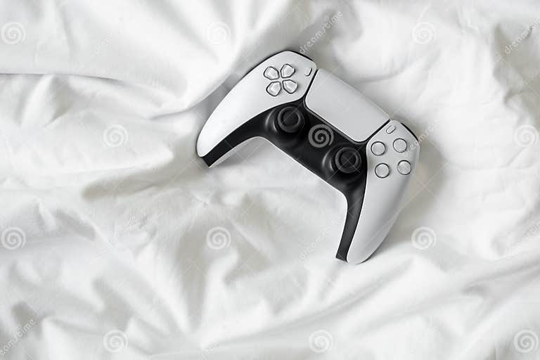 Game Controller, Lying on White Sheets of Bed at Home. Stock Photo ...