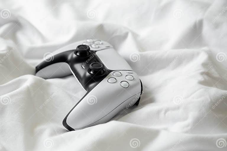 Game Controller, Lying on White Sheets of Bed at Home. Stock Photo ...