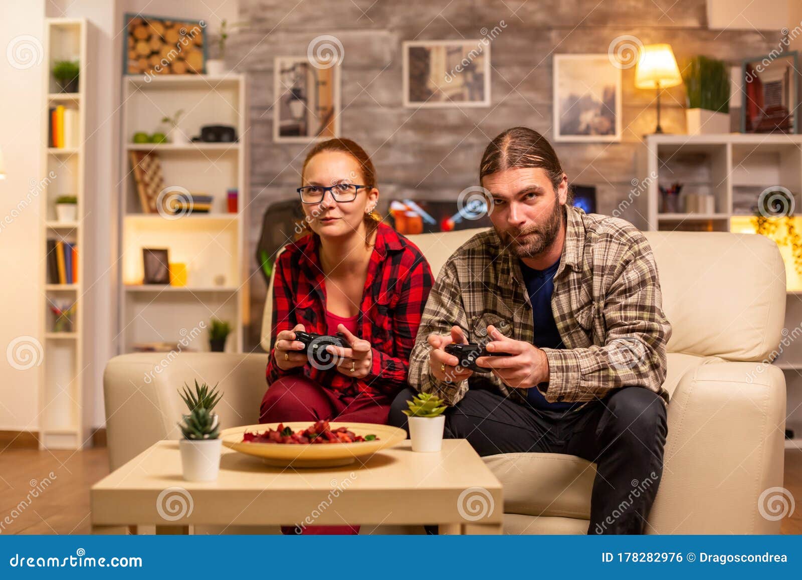 Gamers Couple Playing Video Games on the TV with Wireless Controllers ...