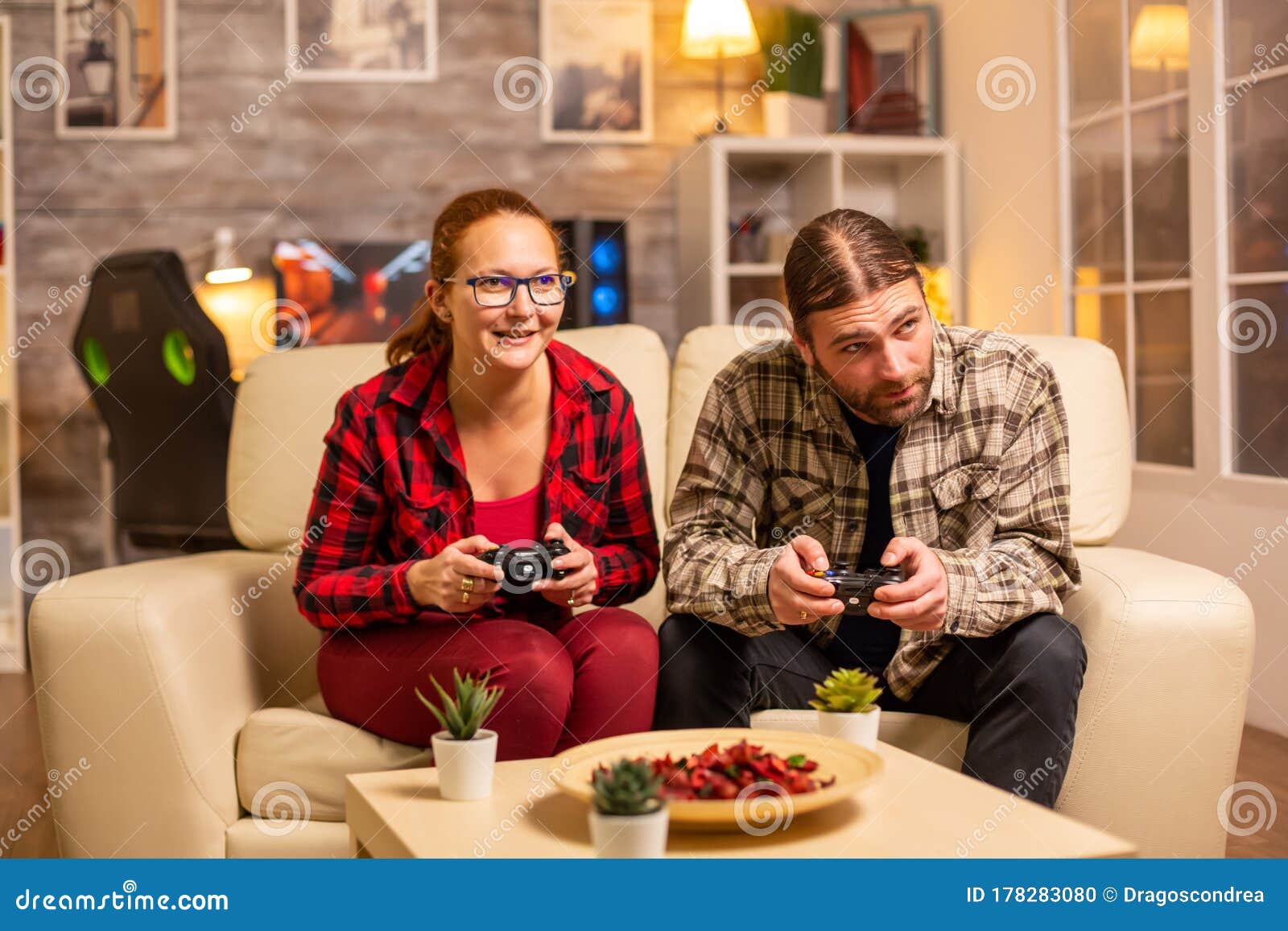 Gamers Couple Playing Video Games on the TV with Wireless Controllers ...