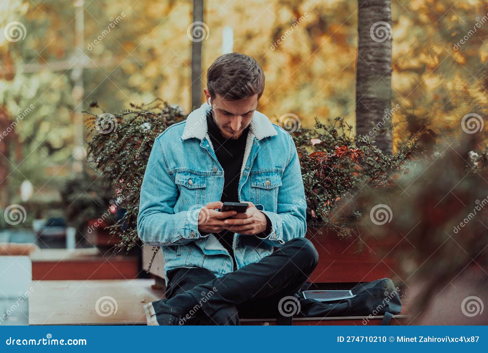 A Gappy Student Sitting in a Park Using a Smartphone and Wireless ...