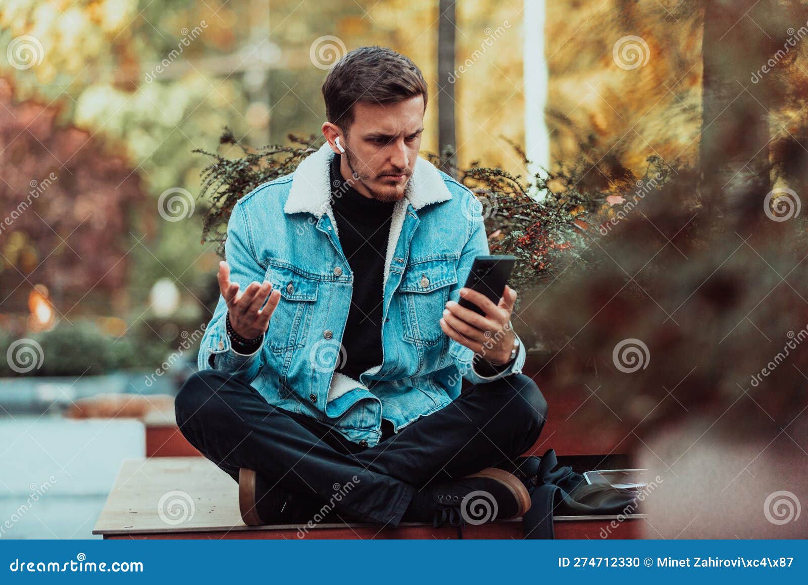 A Gappy Student Sitting in a Park Using a Smartphone and Wireless ...