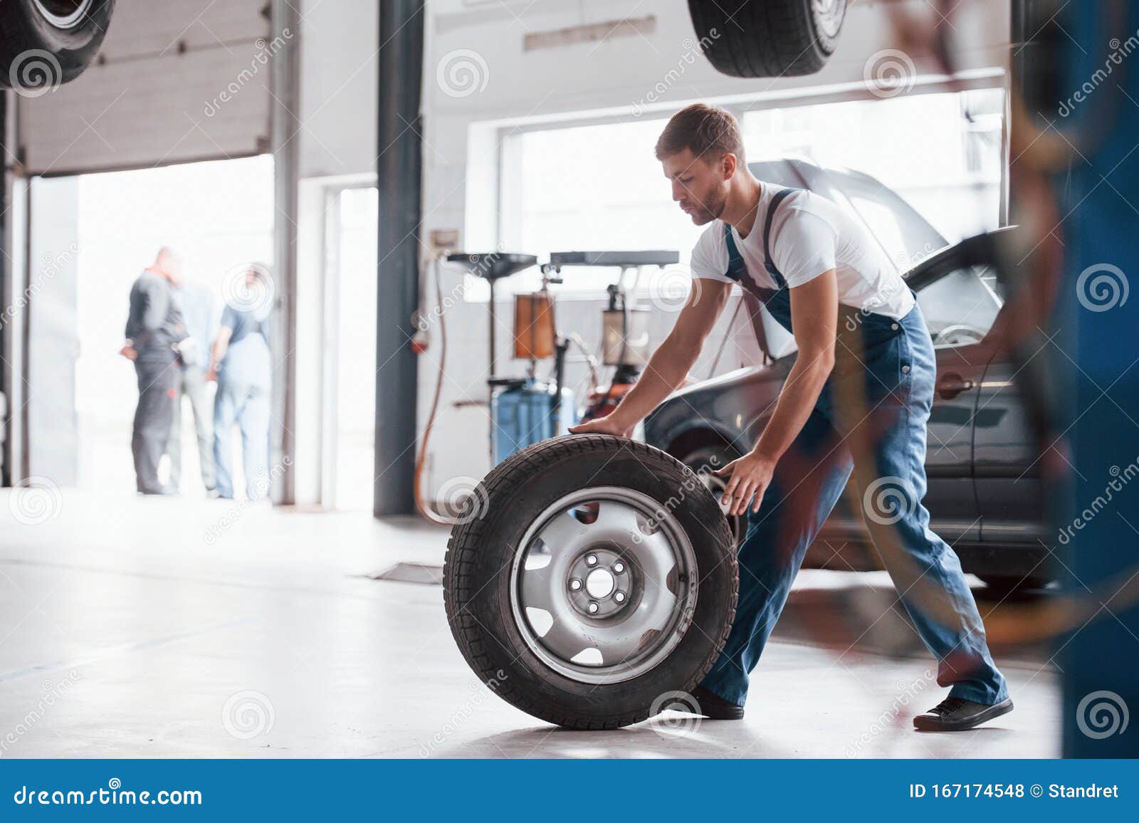 In the Garage. Employee in the Blue Colored Uniform Works in the ...