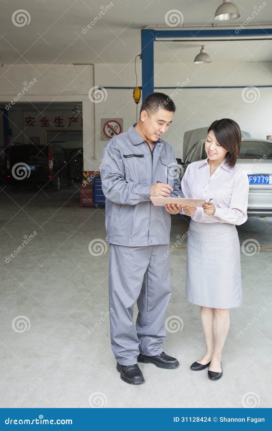 Garage Mechanic Explaining To Customer, Showing Her the Bill Stock ...