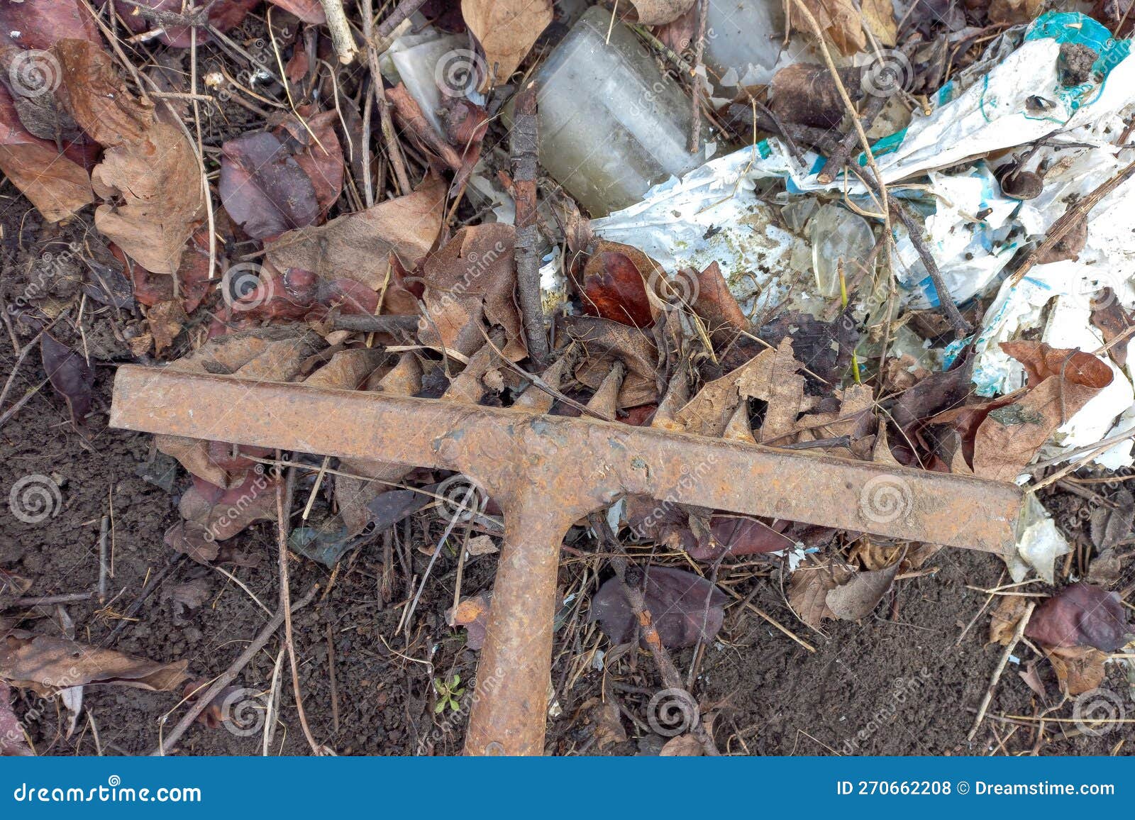 Garbage Dump on the Ground with a Rake and Empty Glass Bottles ...