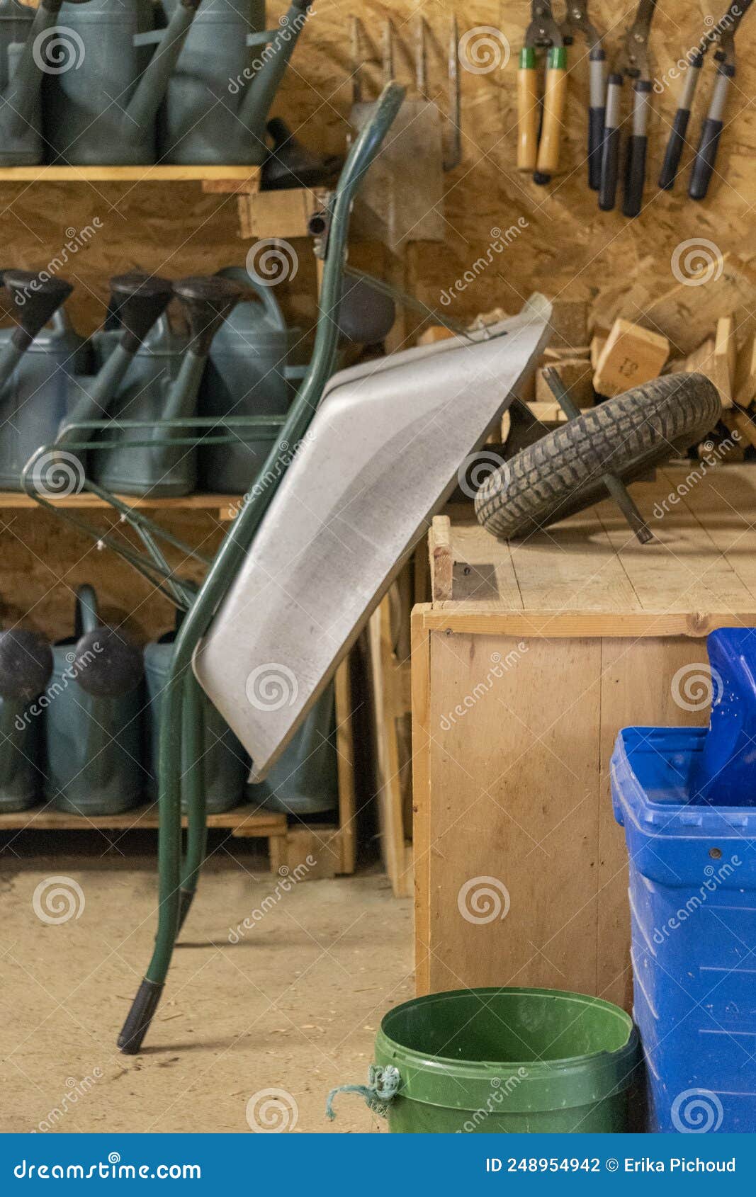 Garden Wheelbarrow Upside Down Against a Workbench, on Which the Wheel ... Garden Wheelbarrow Upside Down Against a Workbench, on Which the Wheel ...