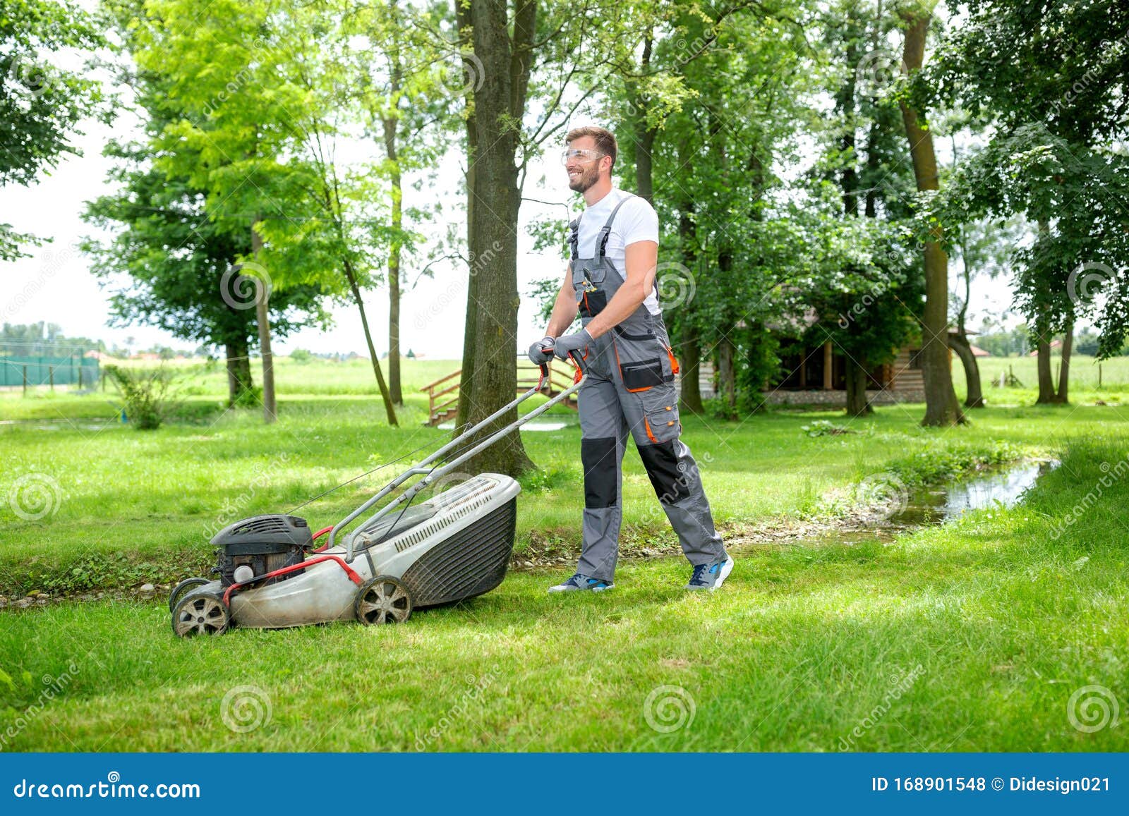 Gardener Trimming Grass with Lawn Mower Stock Photo - Image of fence ...