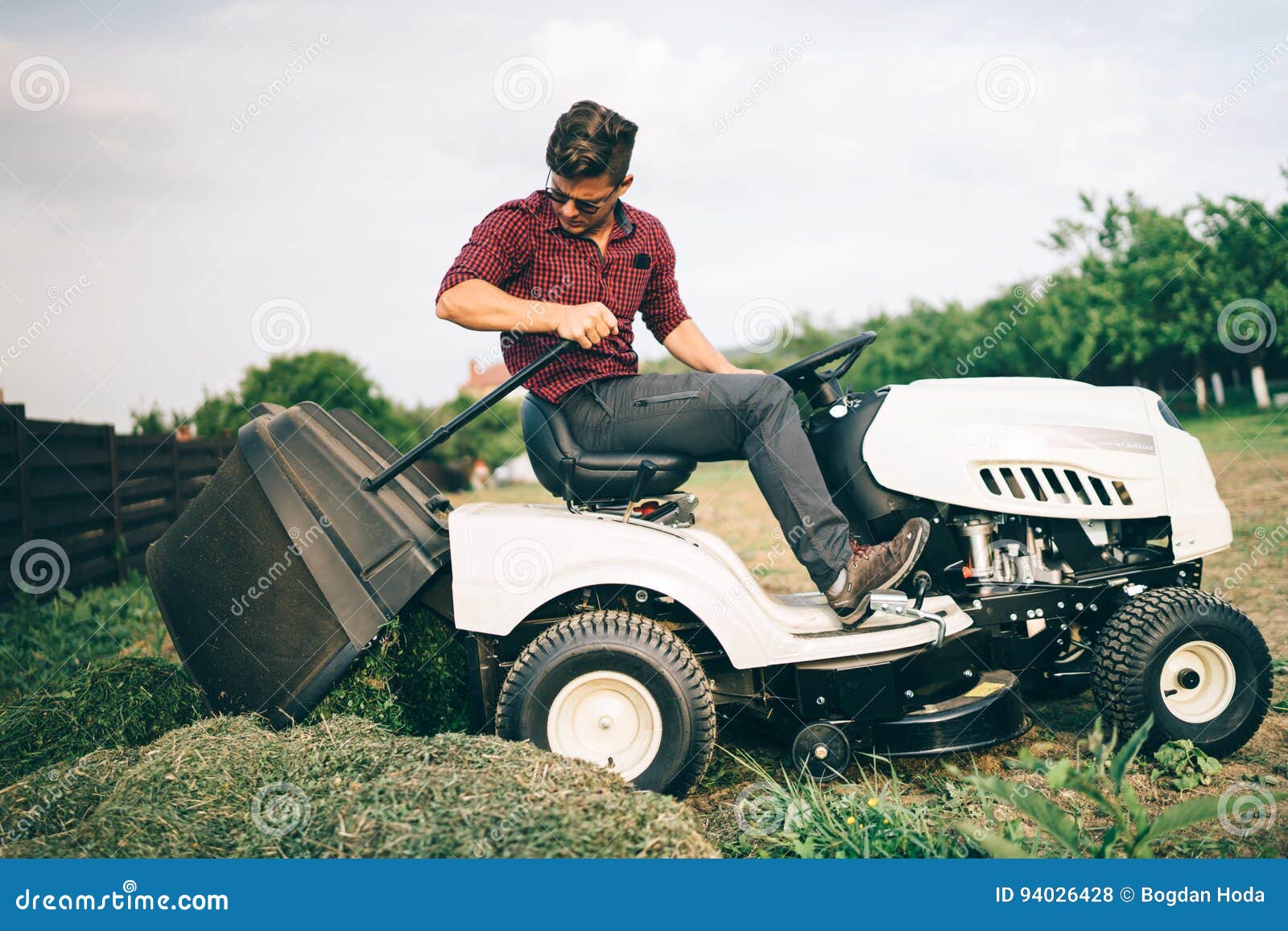 Gardner Doing Landscaping Works and Cutting Grass, Unloading Grass ...