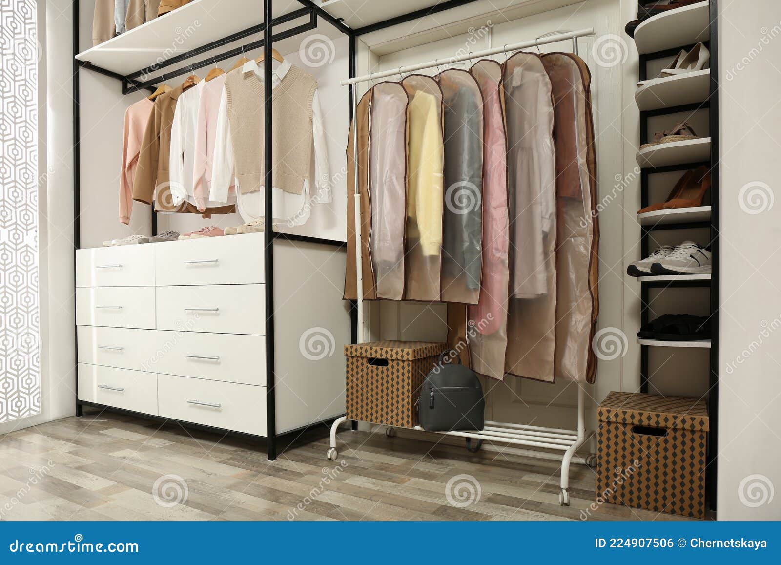 Garment Bags with Clothes on Rack in Room Stock Photo - Image of bags ...