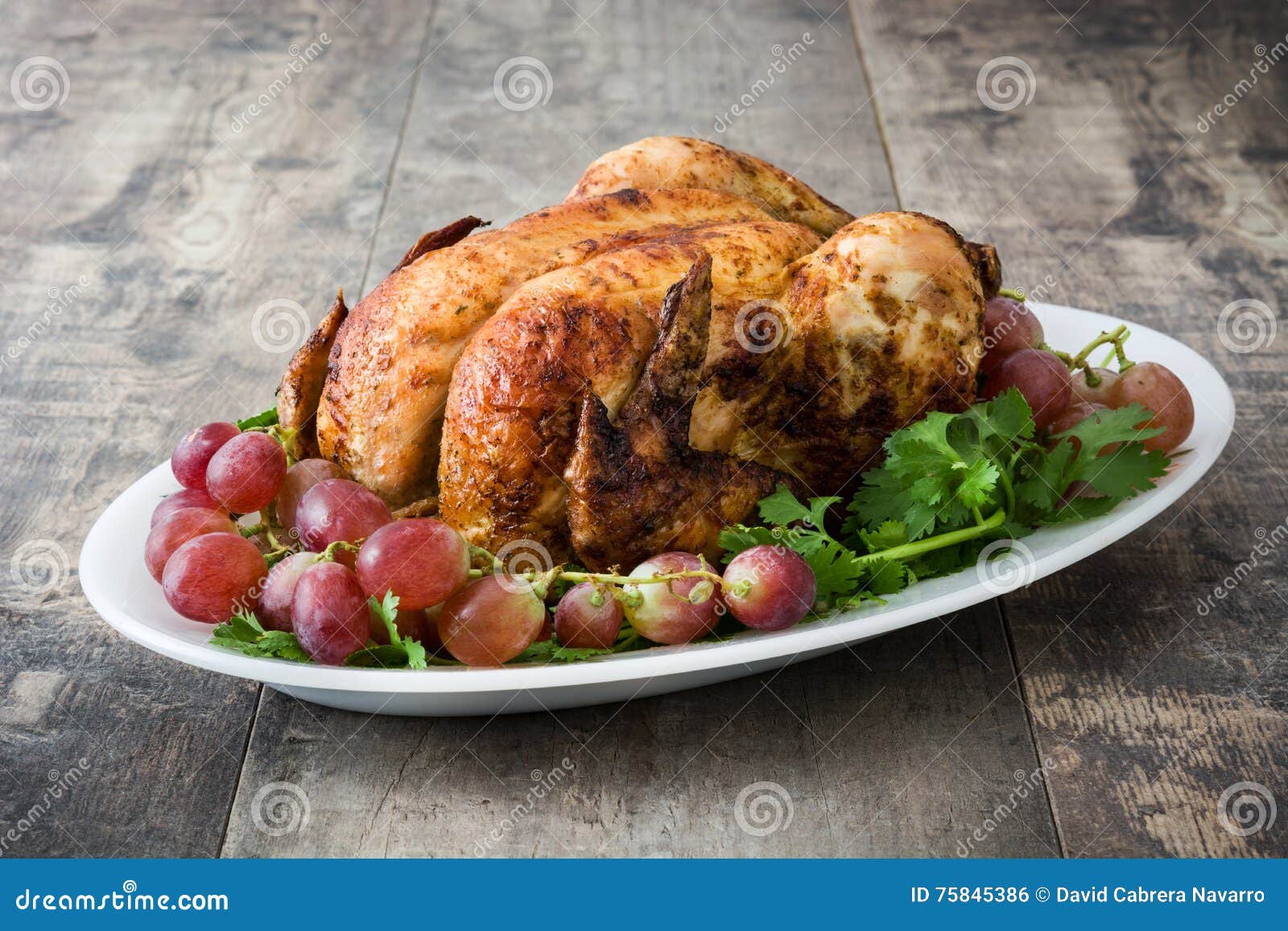 Garnished Roasted Turkey with Grapes and Herbs on a Wooden Table Stock ...