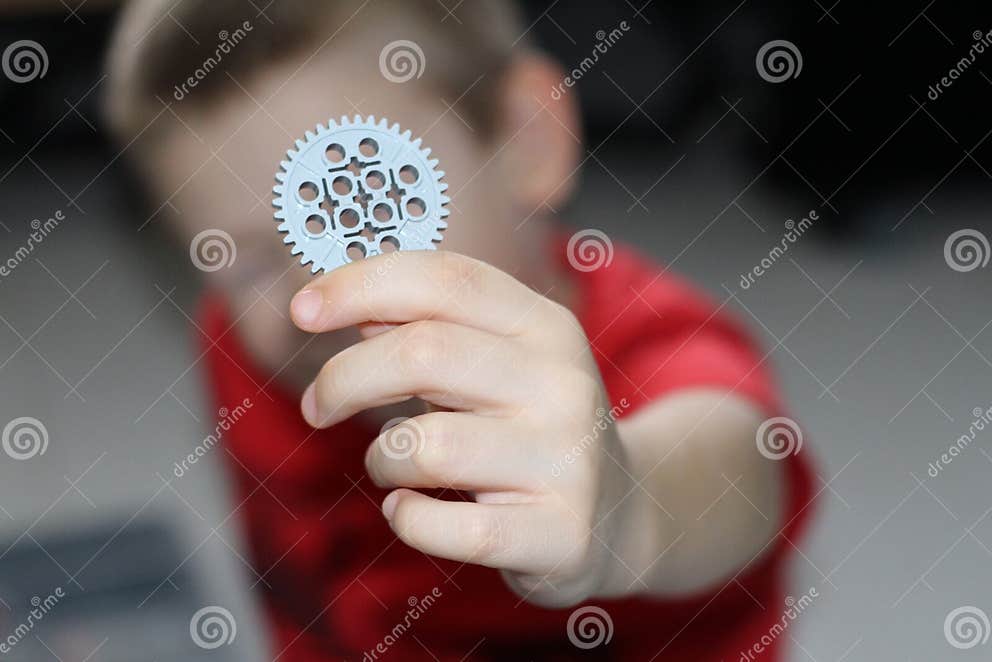 The Gear in the Hand of the Boy. the Gear is Magnified, the Boy is in ...