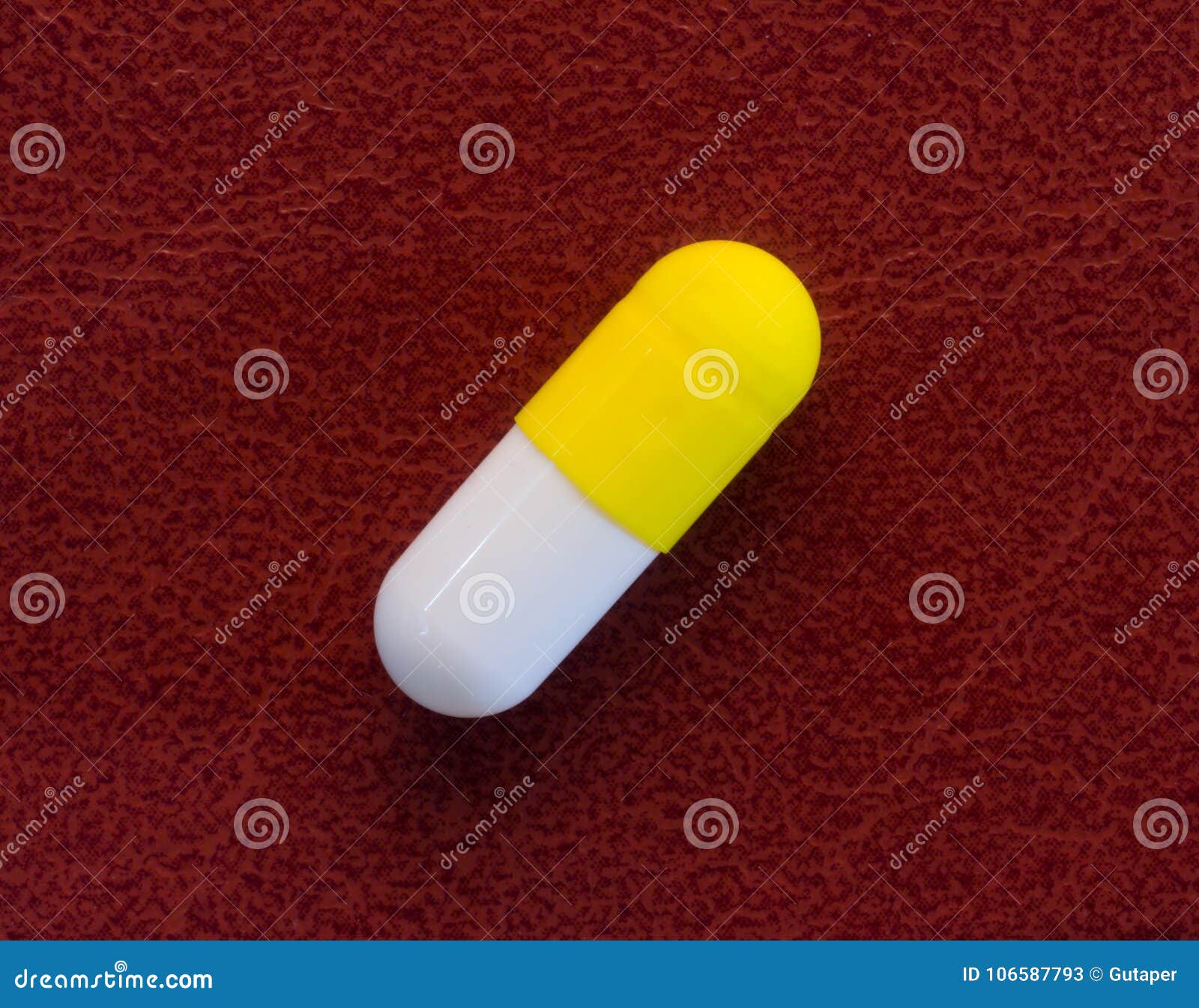 A Gelatin Capsule with a Yellow Cap on a Red Background Stock Image ...