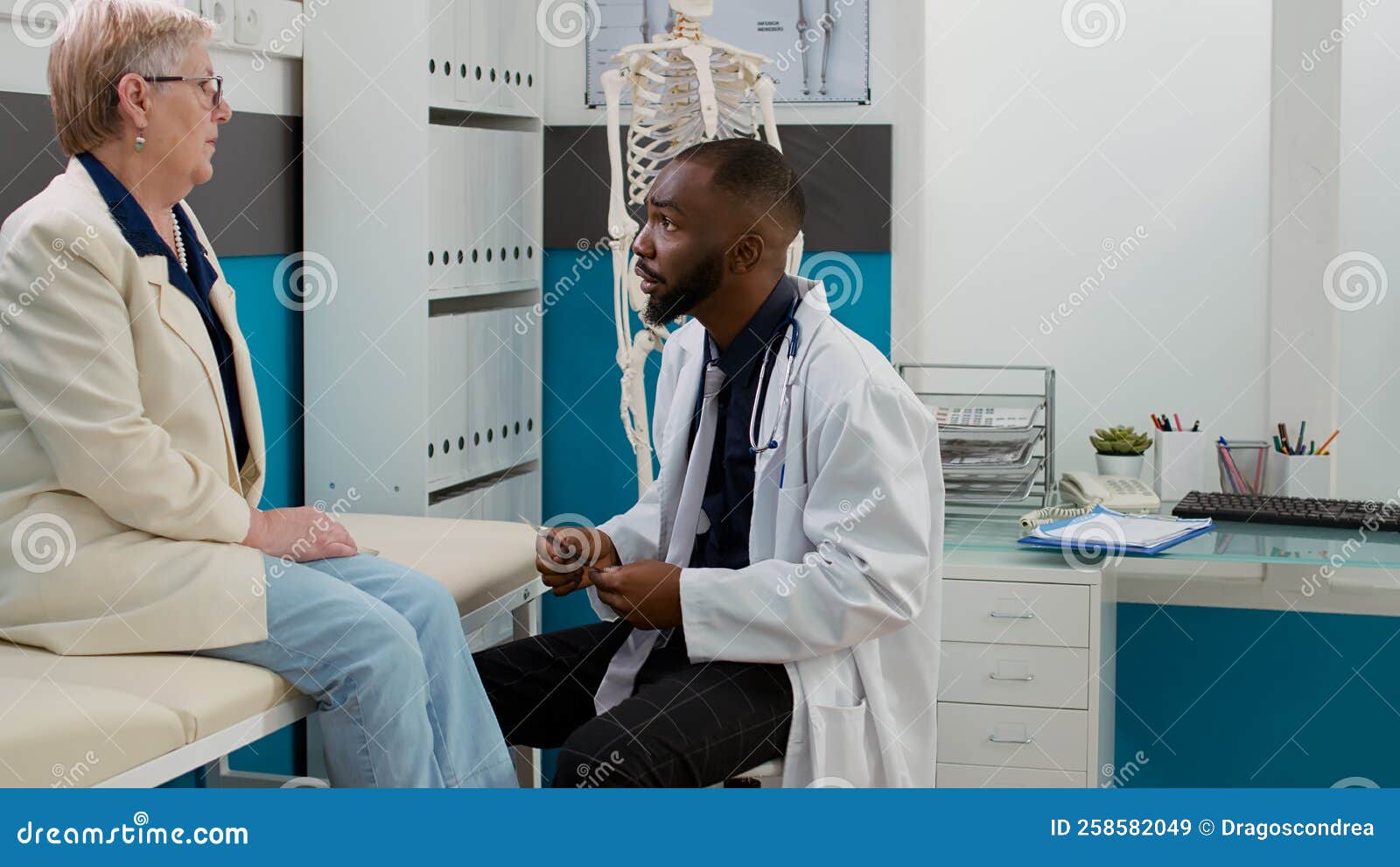 General Practitioner Looking at Bones X Ray with Senior Patient Stock ...