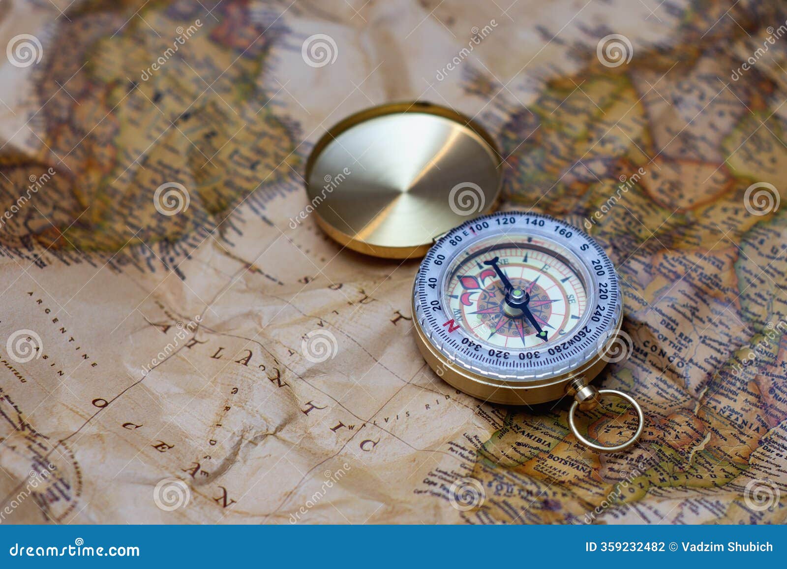 Antique Brass Compass Resting on a World Map, Symbolizing Travel and ...