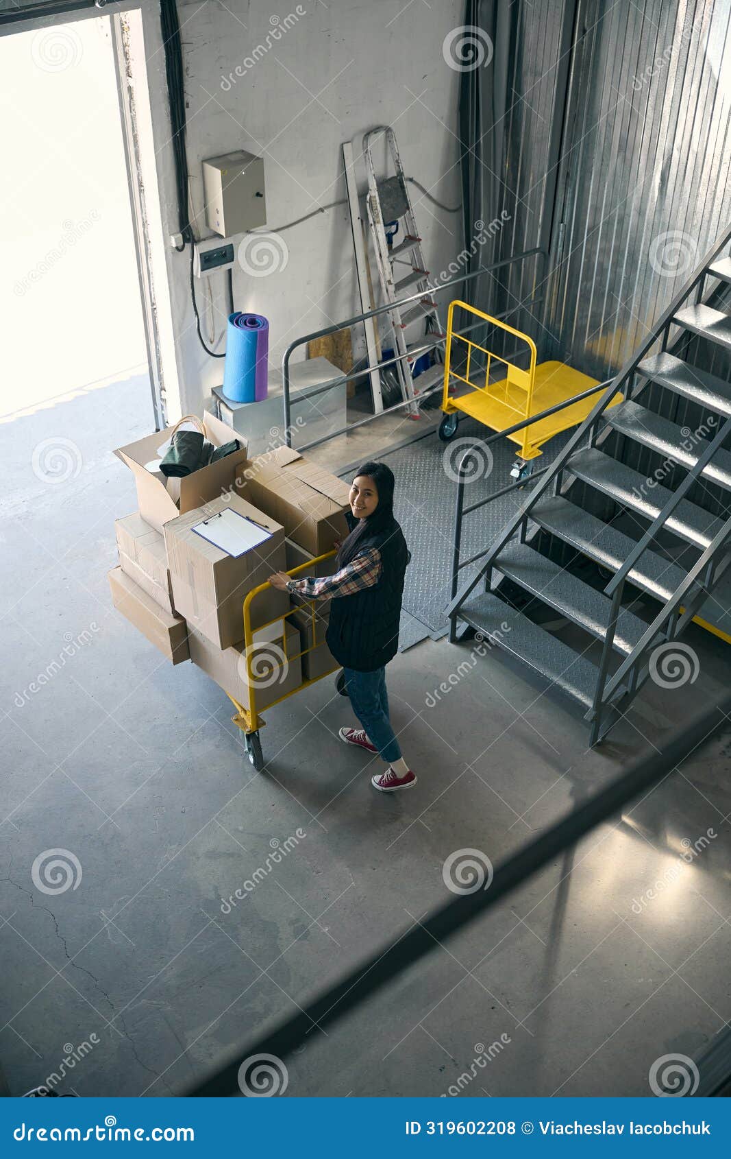 Joyous Loader Posing for Camera while Transporting Goods on Wheeled ...